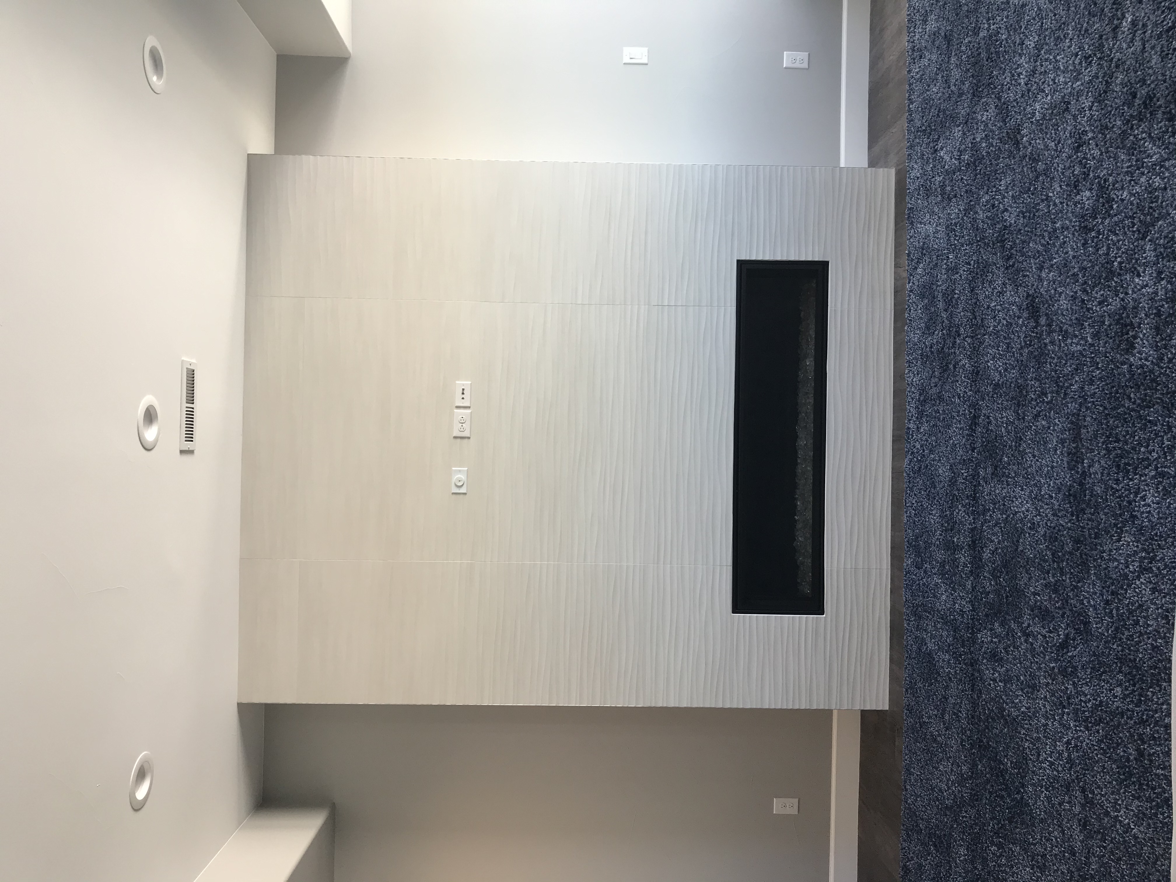 Wavy porcelain tile on the fireplace surround up to the ceiling by ...